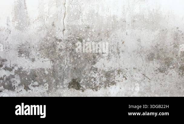 Close-up footage of a weathered, rough concrete wall with stains ...