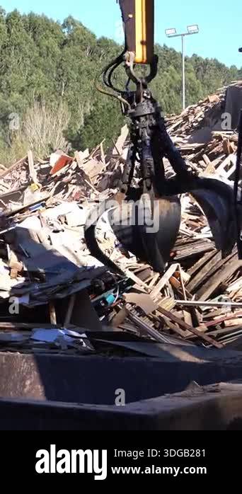 Powerful mechanical claw crane sorting and moving wood waste at ...
