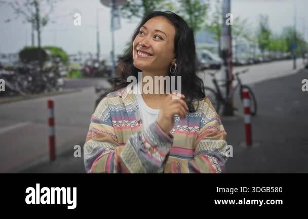 Woman hand on chin pensive pose on a city street near parked bicycles ...