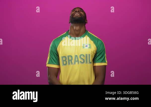 Man wearing yellow and green brasil jersey smiling with head tilted ...