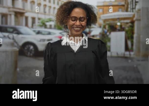 Woman judge smiling with arms raised on a busy city street, wearing ...