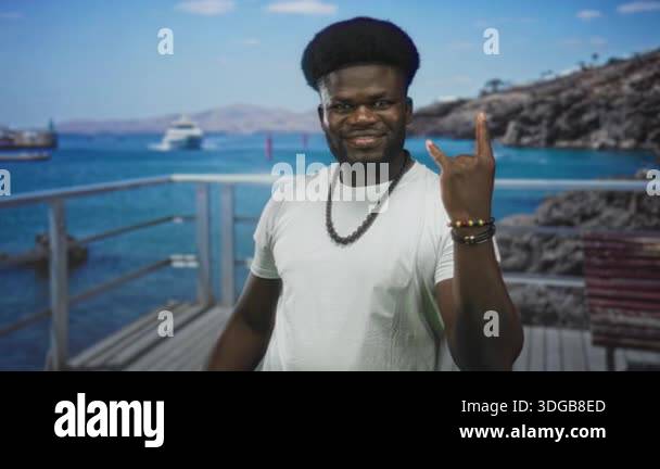 Man makes rock horns sign with right hand wearing white t shirt and ...