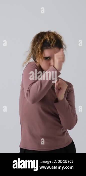 Energetic young woman with curly hair dancing hip hop style, isolated ...