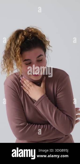 Vertical video of a happy young woman laughing hysterically and wiping ...