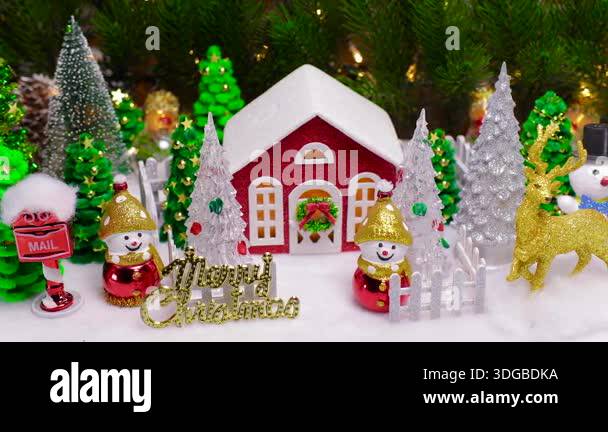A Christmas village with a red house surrounded by snowmen and ...