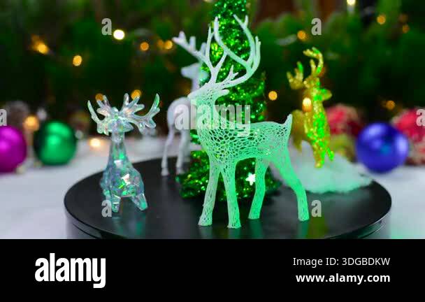 A small Christmas tree surrounded by reindeer rotates against a ...