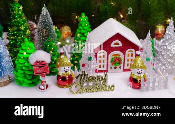 A Christmas village with a red house surrounded by snowmen and ...