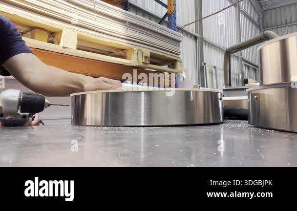 Hands assembling stainless steel lightbox frame using cordless drill ...