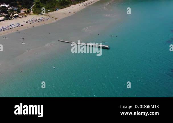 Top down aerial drone view of a long wooden pier extending into the ...