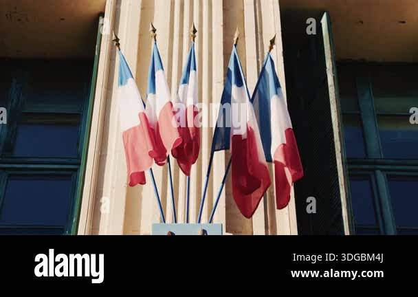 French national flags waving on the facade of a historic building in ...