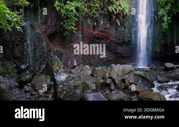 rocky waterfall pool with foamy current, scattered boulders, basalt ...