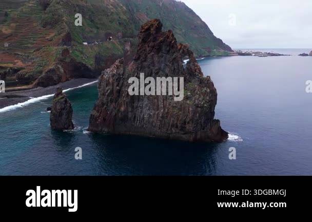 aerial sea stack near coastal village dramatic rock formation rising ...