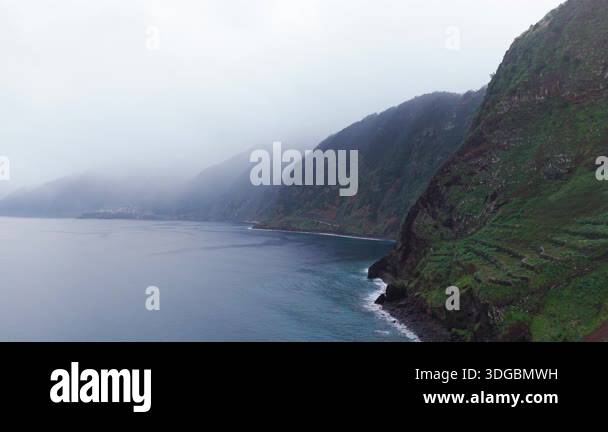 aerial misty cliffs overlooking sweeping bay long verdant escarpment ...