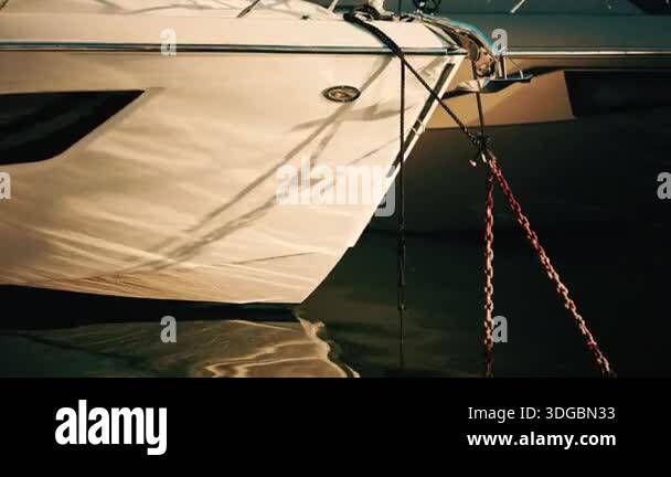Close up of the bow of a luxury yacht with mooring ropes and metal ...