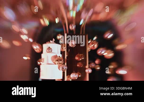 Golden Christmas baubles hanging from a structure alongside a suspended ...