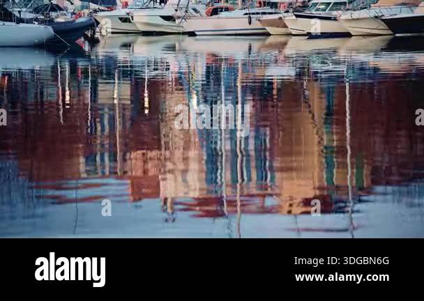 Detailed shot of distorted reflections of buildings and boats on gently ...
