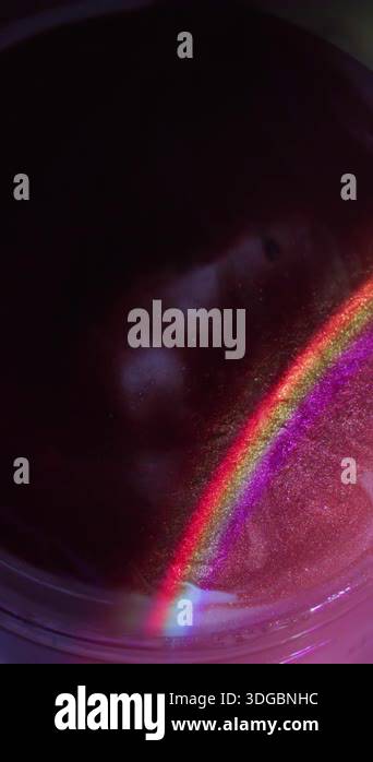 Vertical video. Light texture. Shiny ink. Defocused purple red green ...