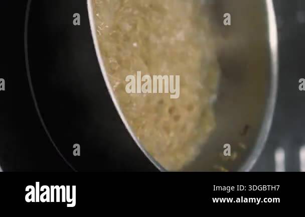 Vertical video. Stewing dish. Hot pilaf. Chef hand adding ladle water ...