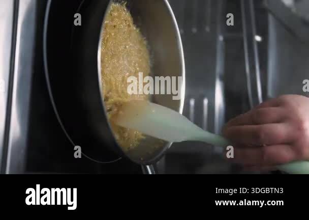 Vertical video. Stirring dish. Cooking hot meal. Chef mixing by spatula ...