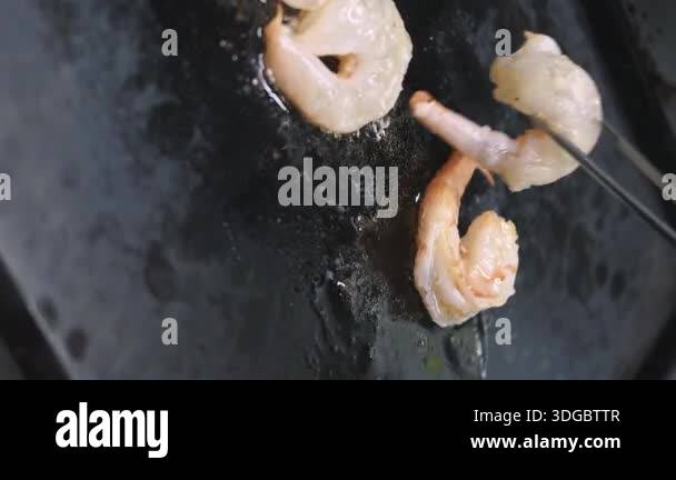 Vertical video. Cooking prawn. Culinary process. Chef hand flipping ...