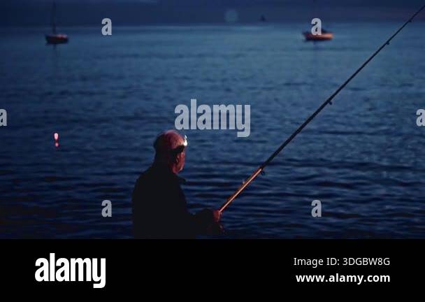 Cannes, France - December 23, 2025: Side view of a fisherman wearing a ...