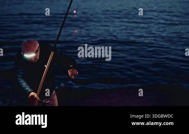 Cannes, France - December 23, 2025: Side view of a fisherman wearing a ...