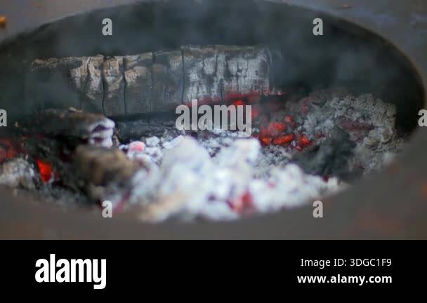 Glowing embers in a barbecue grill. Hot coal producing heat in the ...