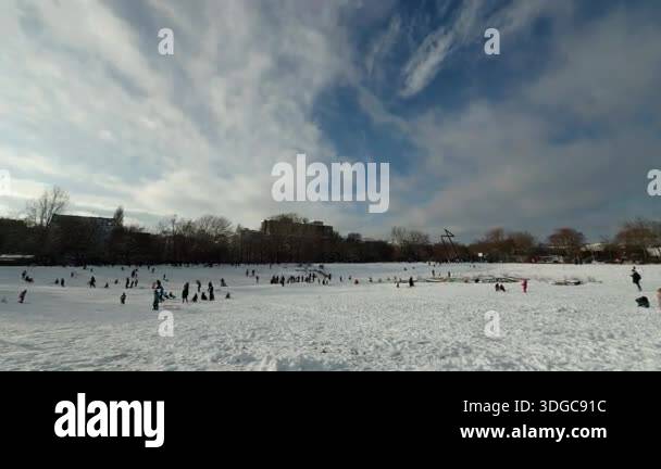 Wide shot of people sledding in a Sunny Day in Gorlitzer Park, Berlin ...