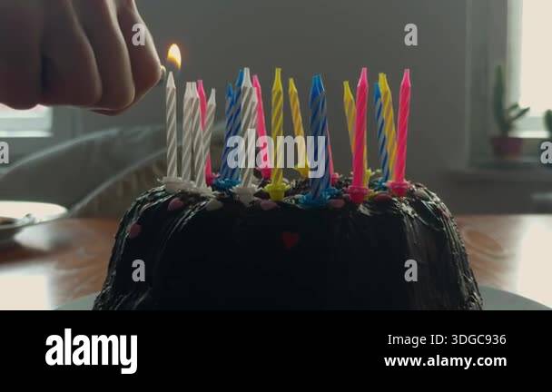 Close-up details of a mother lightning candles on homemade chocolate ...