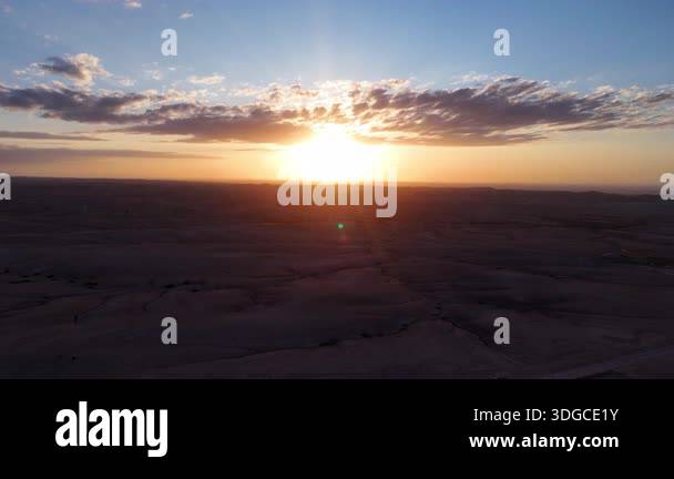 Sun flare sunrise over barren expanse with radiant rays backlighting ...