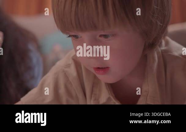 ALMATY, KAZAKHSTAN - MAY 07 2025: Young boy studies paper on floor ...