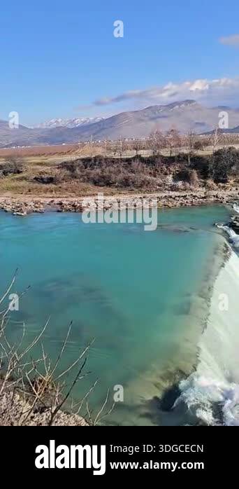 Aerial or top view of a waterfall cascading among rocky cliffs. Flowing ...