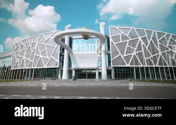 Sports arena stands with patterned panels and glass lobby. Central ring ...
