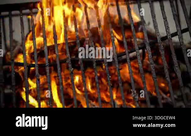 Intense hot flames flickering and rising through the grates of a ...