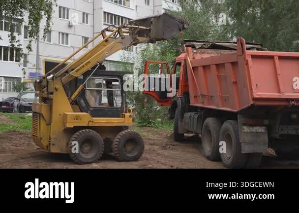 ALMATY, KAZAKHSTAN - MAY 07 2025: Small earthmover loads dirt into dump ...