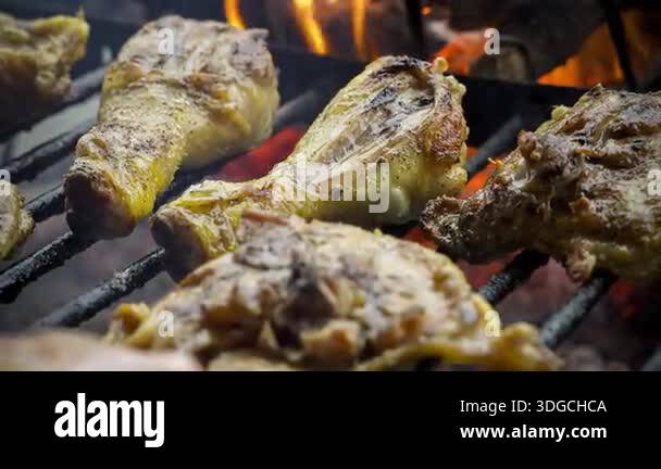 Delicious chicken drumsticks and thighs cooking on a hot barbecue grill ...