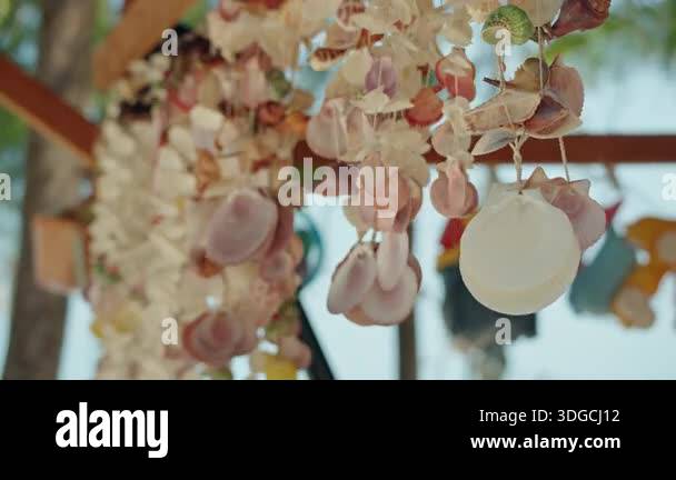 Close up of hanging seashell decorations swaying in the breeze ...