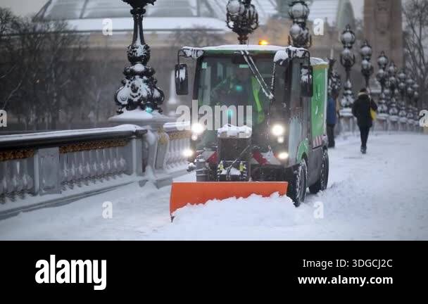 Snow removal vehicle clearing fresh snow from Pont Alexandre III in ...