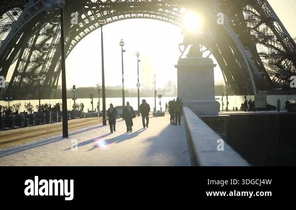 Winter scene in Paris with people walking on a snow-covered path near ...