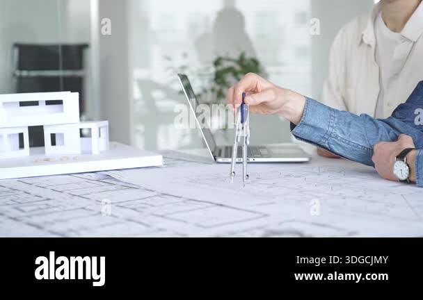 Architects collaborating on building design, discussing blueprints and ...