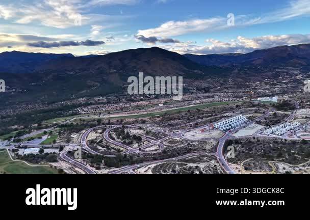 stadium highway interchange beneath mountain, looping ramps and parking ...