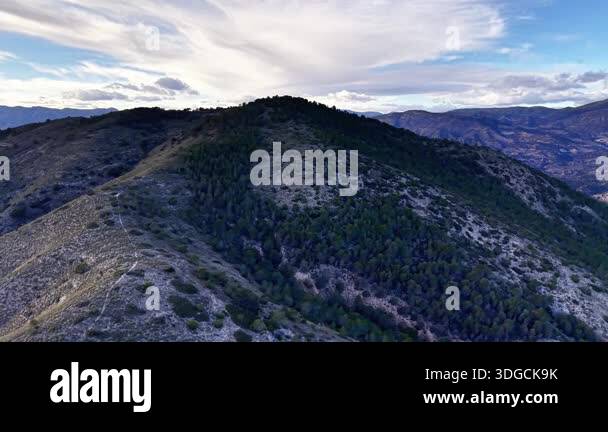 ridge sunrise with rugged rocky slopes, pale dawn light accentuating ...