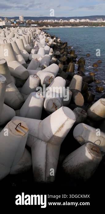 Video of massive concrete tetrapod breakwater blocks on a seacoast ...