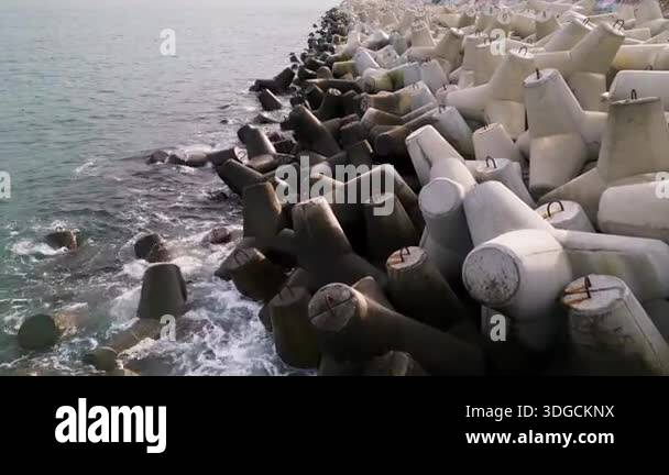 Video of massive concrete tetrapod breakwater blocks on a seacoast ...