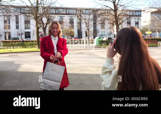 Young female photographer taking pictures of her elegant friend. The ...