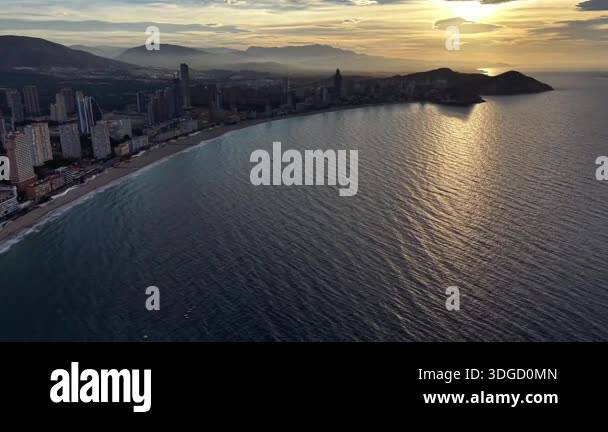 Sunset Reflection On Rippled Ocean Water Near Coastal Skyline, Golden ...