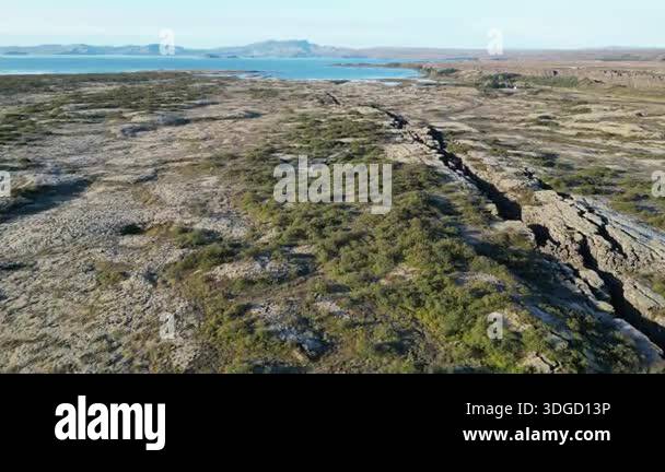 Icelandic Plate Fault. A large, rocky field with a body of water in the ...