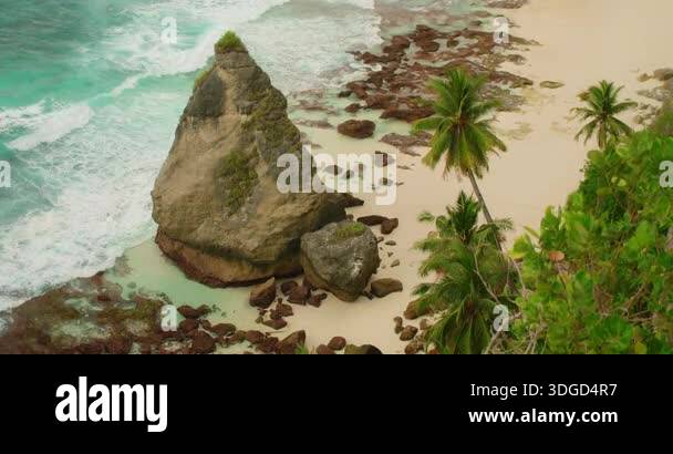 Tropical palm trees and rock formations line white sand at Diamond ...