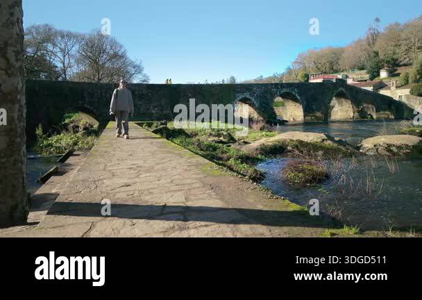 Slow motion footage of a pilgrim walking along a stone path on the ...