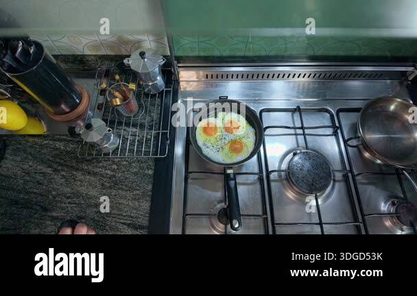 Personal perspective view of a mans hands seasoning three fried eggs ...